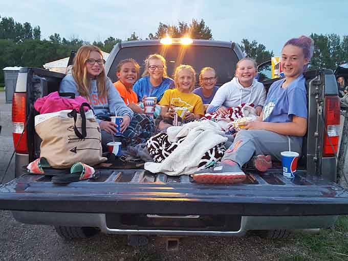 Young moviegoers pile into the truck bed, armed with blankets and the kind of excitement only drive-ins inspire.