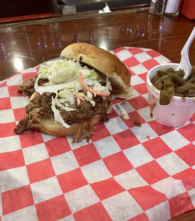 A pulled pork sandwich piled so high it requires both hands and zero shame to eat.