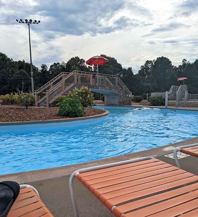 The inviting pool stretches out beneath dramatic clouds, offering respite from summer heat with style and grace.