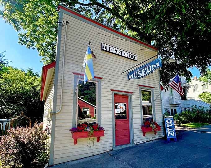 The Old Post Office Museum preserves small-town postal history with red trim that pops against white clapboard siding.
