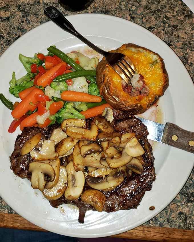 That loaded baked potato deserves its own standing ovation alongside the beautifully grilled steak and mushrooms.