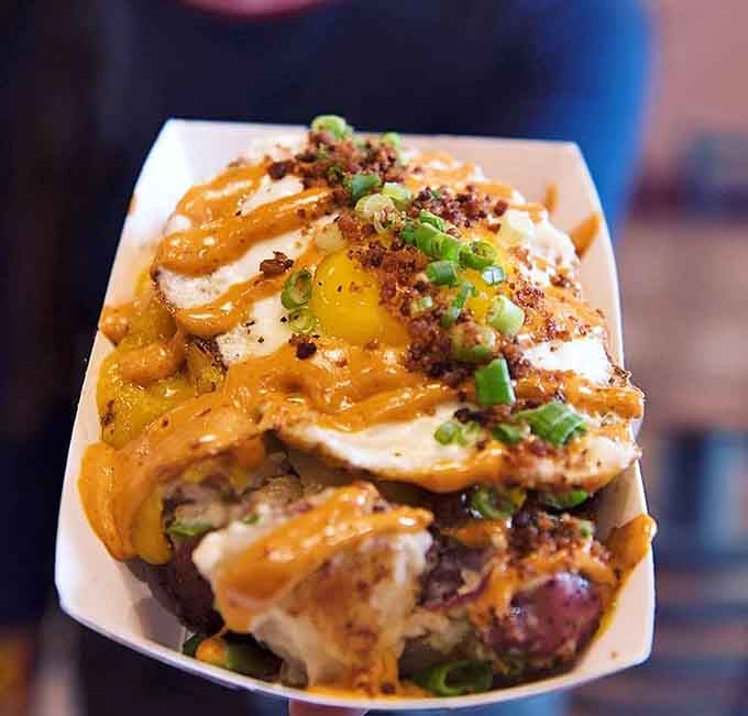 Golden hash topped with a runny egg, scallions, and enough cheese to make your cardiologist schedule an intervention.