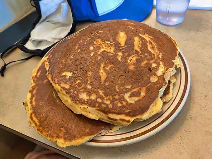 Three pancakes stacked like the Leaning Tower of Pisa, except way more delicious and structurally questionable.