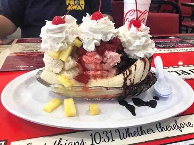 Three scoops of ice cream nestled between banana halves, proving that fruit counts as health food, right?