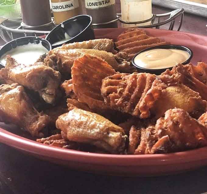 Wings piled high like edible treasure, smoked to crispy-skinned glory that redefines bar food expectations.