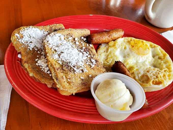French toast dusted with powdered sugar sits next to eggs and bacon like the breakfast dream team they were born to be.