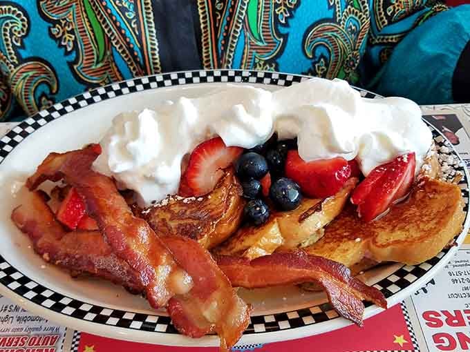French toast piled high with fresh berries, bacon, and whipped cream is basically dessert disguised as breakfast, and nobody's complaining.
