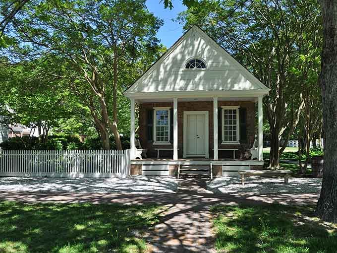 Dappled sunlight on white clapboard siding creates the kind of peaceful scene that makes retirement brochures jealous of reality.