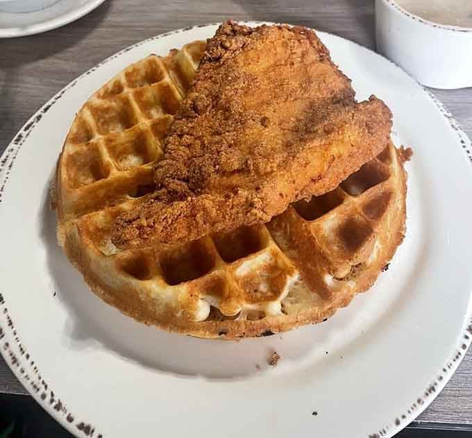 Crispy fried chicken perched on a waffle like it just conquered Mount Delicious and planted its flag.