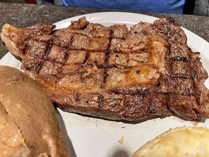 Look at those beautiful grill marks on that ribeye, the kind of steak that makes vegetarians question everything.