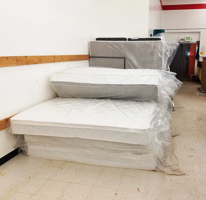 Brand new mattresses still wrapped in plastic, because even thrift stores know comfort matters at bedtime.