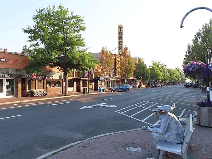 Quiet downtown Bend street with theater sign, local shops, and charming statue invites a relaxed stroll through this welcoming Oregon community.