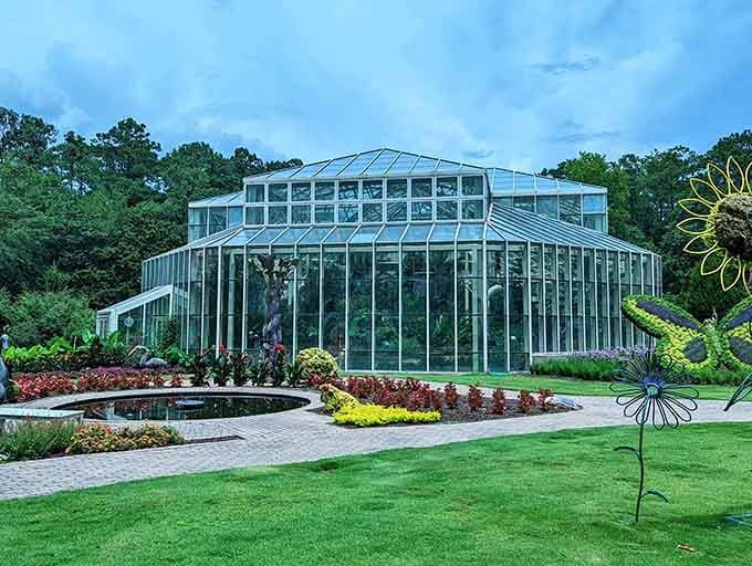 That stunning glass conservatory surrounded by vibrant gardens proves Mother Nature knows how to put on a show.