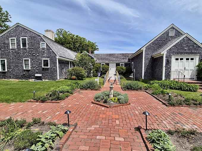 Brick pathways lead through weathered Cape Cod buildings, creating a courtyard that whispers of maritime history and summer breezes.