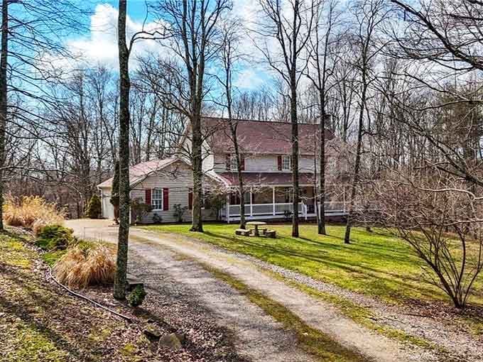 Peaceful country homes nestle among bare trees along a gravel drive, offering the kind of tranquil setting that makes city stress evaporate.
