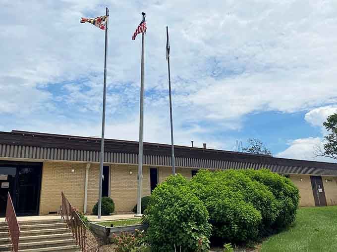 Three flags wave proudly above manicured grounds honoring those who served with dignity and quiet respect.