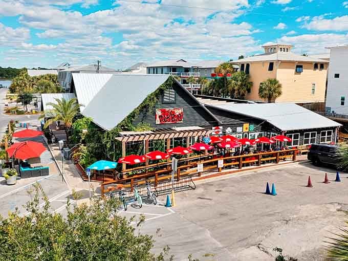 Those bright red umbrellas pop against the coastal sky, promising cold drinks and fresh seafood after a long beach day.