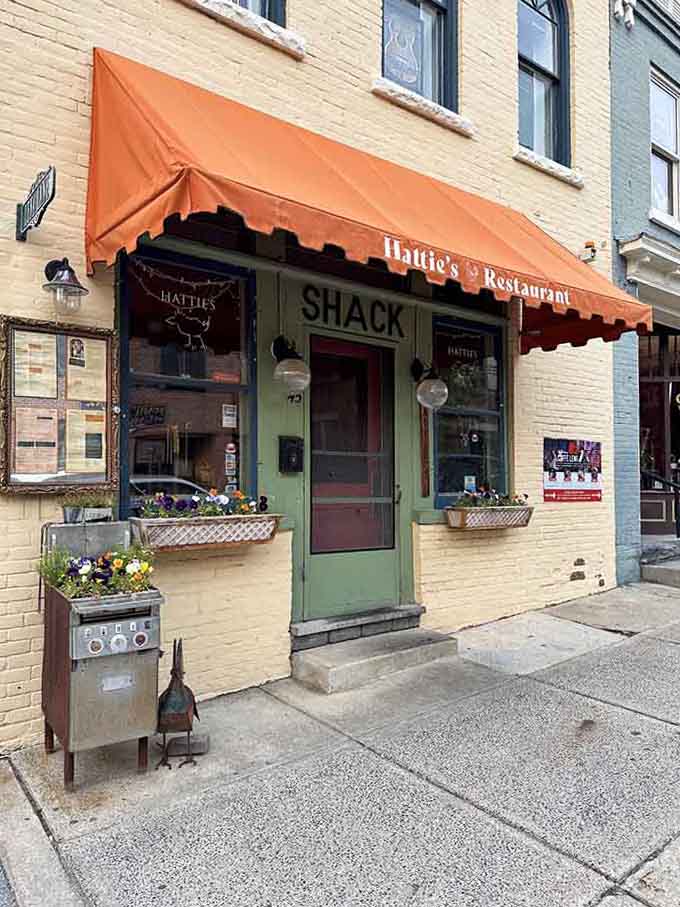 The orange awning and flower boxes add charm to this cozy corner spot that looks like it serves hugs with every meal.