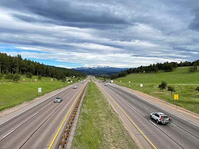 Rolling green hills meet distant peaks along this highway, proving Colorado's beauty extends beyond the mountains.