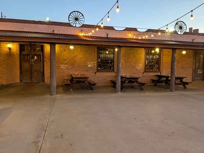 Wagon wheels and string lights create rustic charm at this outdoor patio perfect for starlit dinners.