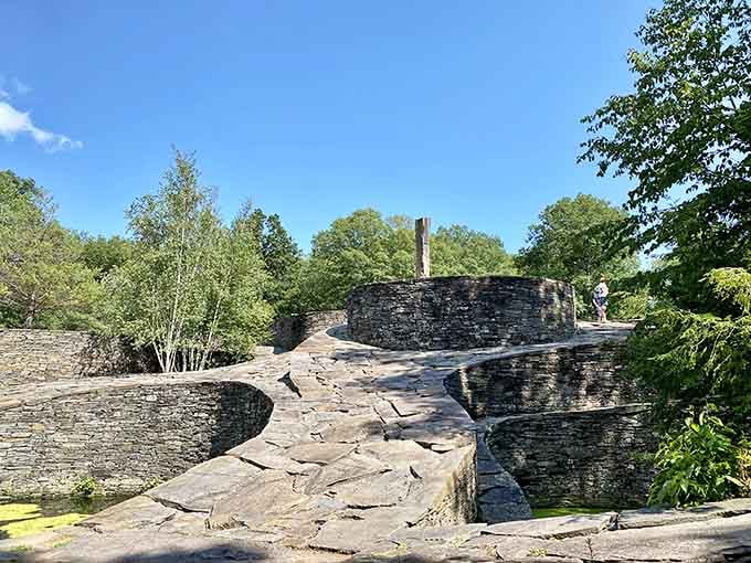 Curved stone platforms flow like frozen waves across this remarkable sculpture garden carved from an old quarry.