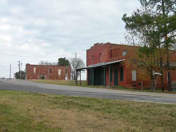 Red brick buildings stand quietly along the roadside, witnesses to generations of community life and change.