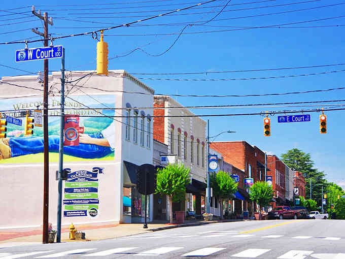 Main Street charm meets mountain town magic where colorful murals brighten storefronts under that brilliant Carolina blue sky.