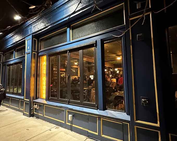 The sophisticated navy and gold exterior at twilight sets the stage for modern steakhouse dining with neighborhood warmth and genuine hospitality.
