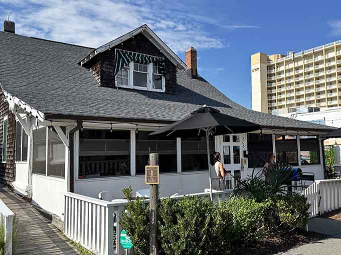 The historic cottage architecture stands proud against modern towers, serving timeless seafood with genuine coastal character and grace.