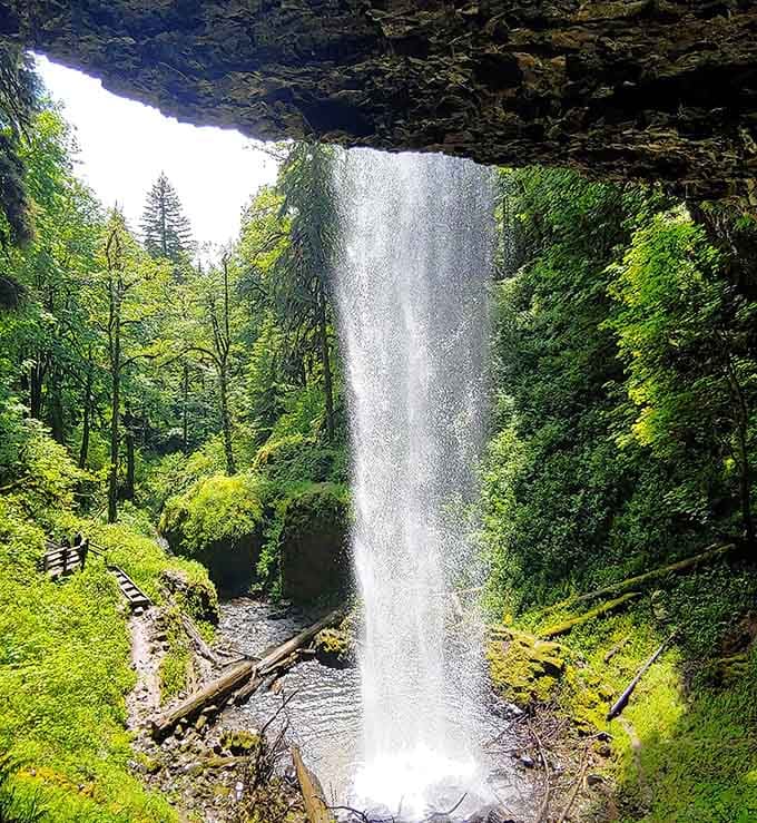 Behind the rock overhang, you'll find nature's own private viewing box for this spectacular waterfall performance below.