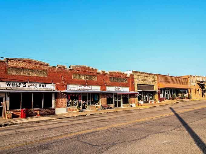 Wolf's Sport Bar anchors this golden-hour street where long shadows and weathered brick tell tales of countless game days.