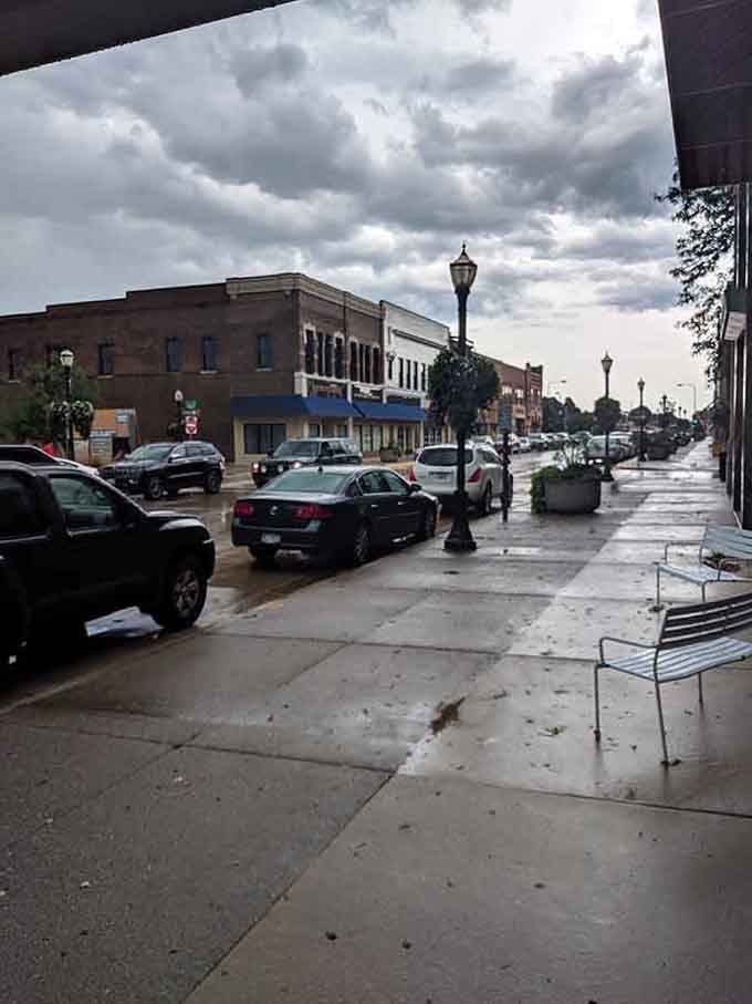 Rain-slicked sidewalks reflect the streetlights, adding romantic atmosphere to this timeless downtown scene.