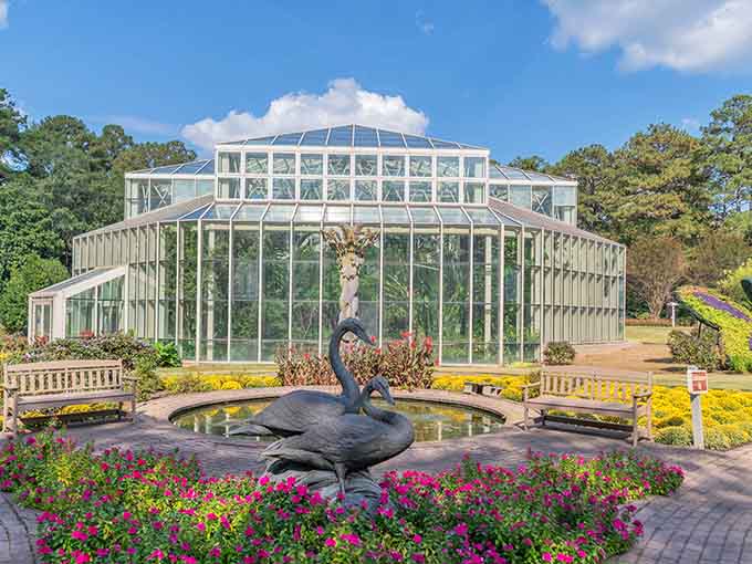 A graceful peacock fountain adds whimsy to this botanical paradise where flowers bloom in every imaginable color.