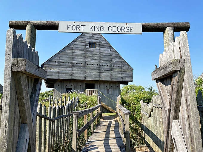 The fort entrance beckons across a wooden bridge, its rough-hewn logs and primitive construction speaking of desperate times and isolation.