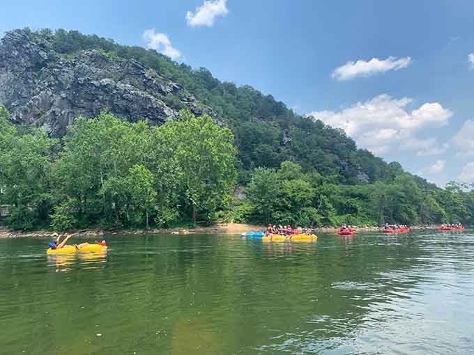 Colorful tubes drift lazily down the Shenandoah River beneath dramatic cliffs, creating the perfect summer escape.
