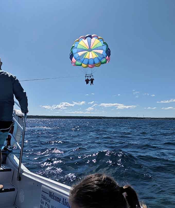 Floating peacefully above the blue expanse while the boat crew watches&mdash;this is pure Michigan summer magic happening.