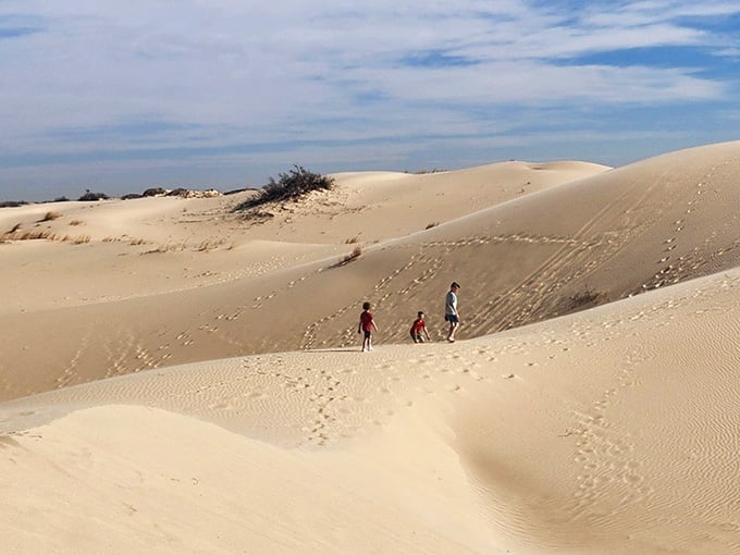 Tiny figures climb the massive dunes, showing just how impressively tall these sandy mountains really are&mdash;bring your sled!
