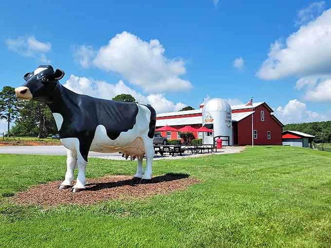 Behind the cheerful cow mascot, the red barn and rolling pastures paint a picture of dairy farm perfection.