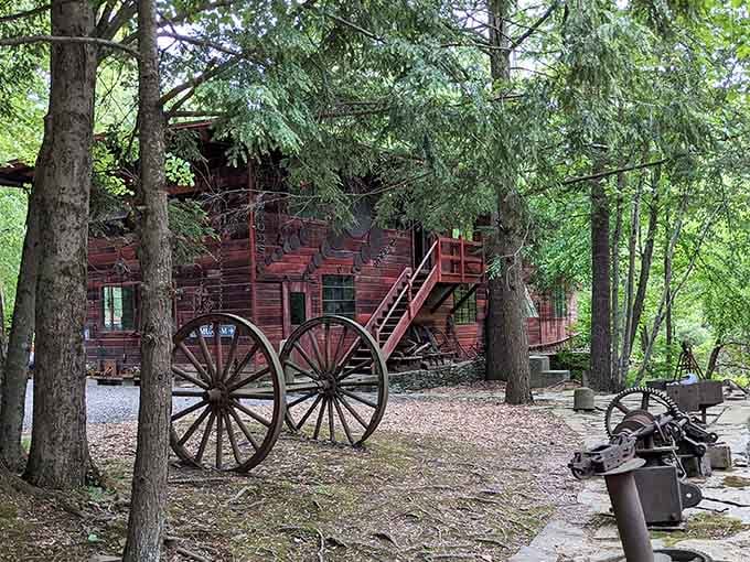 Giant wagon wheels and a rustic red cabin transport visitors back to simpler times in the Adirondack wilderness.