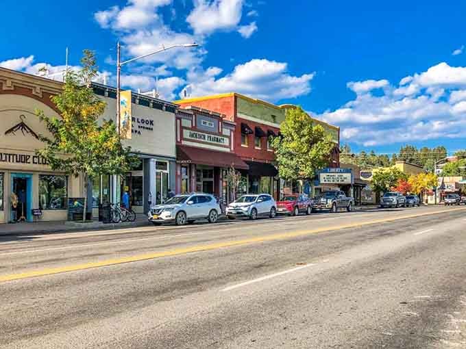 Blue skies and puffy clouds hover over main street where local shops invite exploration on perfect days.
