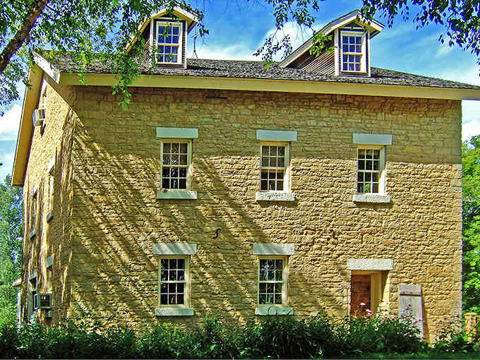 Butter-yellow stone walls glow warmly in afternoon light, this historic building standing as solid as the day craftsmen finished it.
