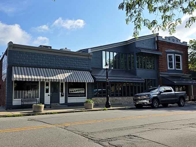 The charming mix of brick, siding, and awnings creates an inviting streetscape perfect for a leisurely seafood dinner.