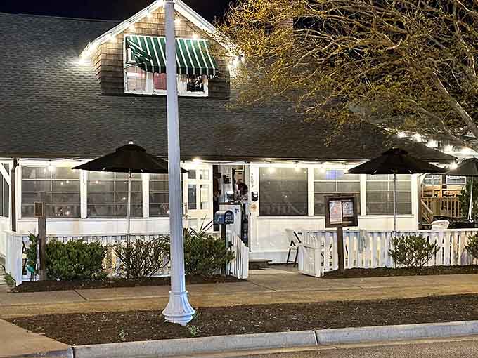 Evening illumination highlights this charming establishment's classic appeal, where elegant dining meets beachside sophistication beautifully.
