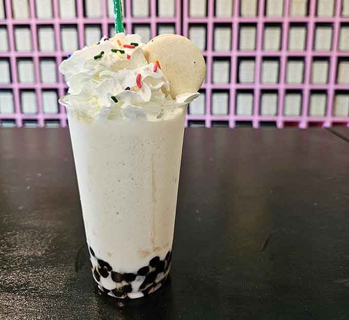 Layered perfection topped with whipped cream and a macaron, because excess is the whole point.