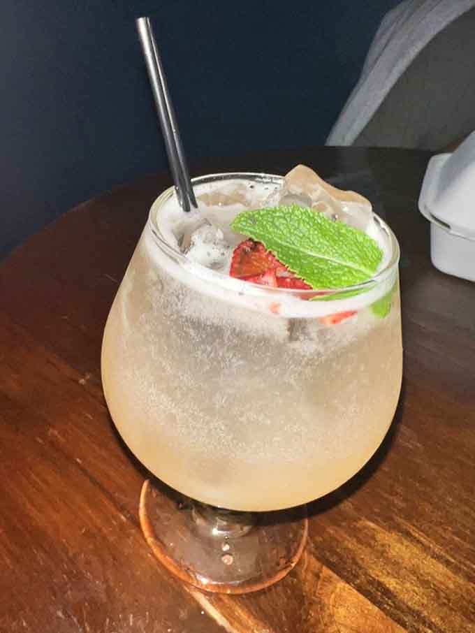 A cocktail garnished with fresh mint and strawberries that tastes like summer decided to stick around.
