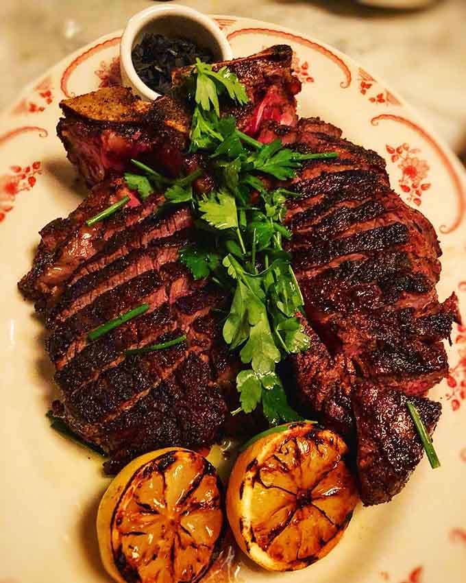 A perfectly charred steak that looks like it just won the lottery and wants to share its good fortune.