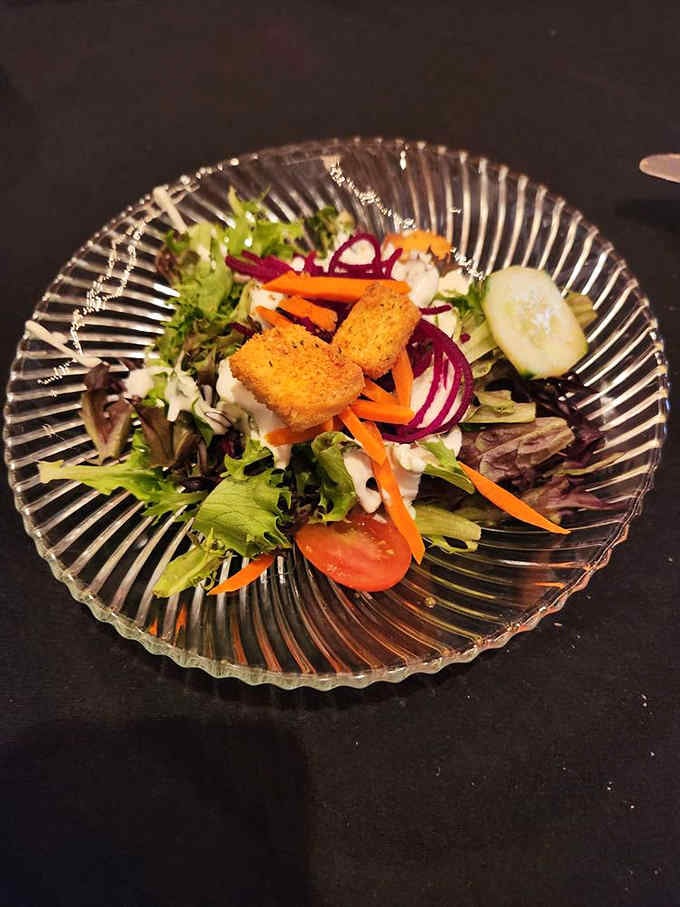 Fresh greens on a vintage glass plate, because even your salad deserves to feel fancy at Bastien's.