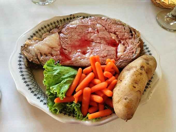 Prime rib sliced thick and blushing pink, served with a baked potato that could feed a small village.
