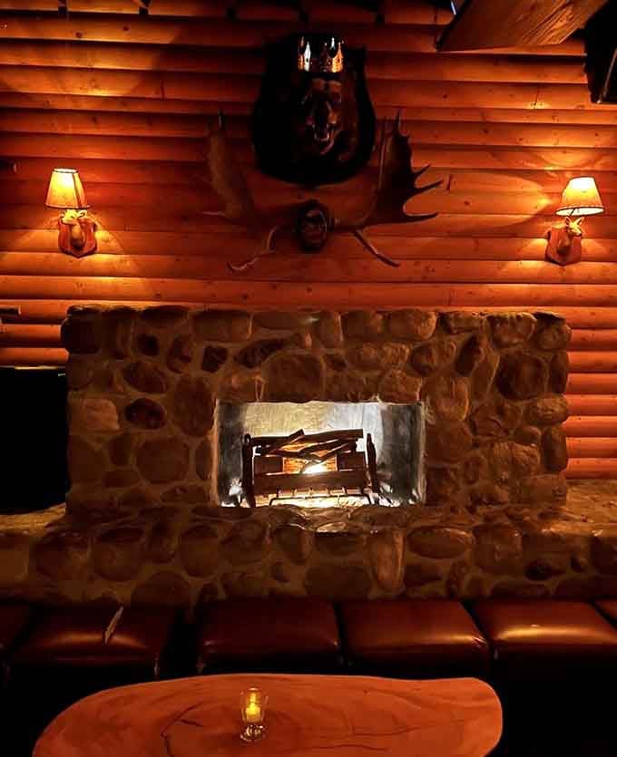 This stone fireplace anchored by a bear head mount creates ambiance that's equal parts cozy and slightly intimidating.