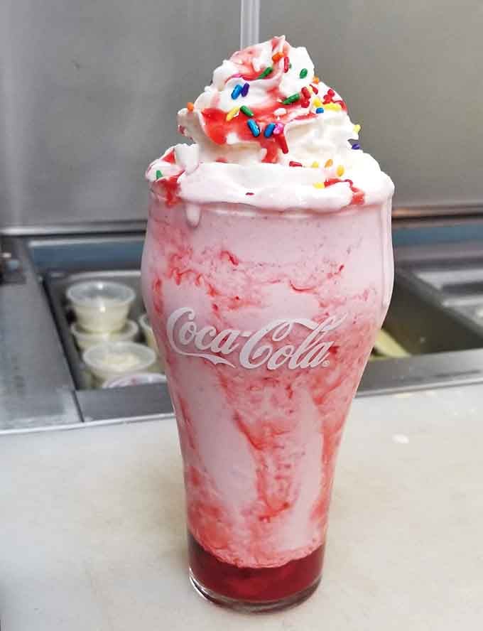 A strawberry milkshake topped with whipped cream and sprinkles, because sometimes you need dessert in a glass.